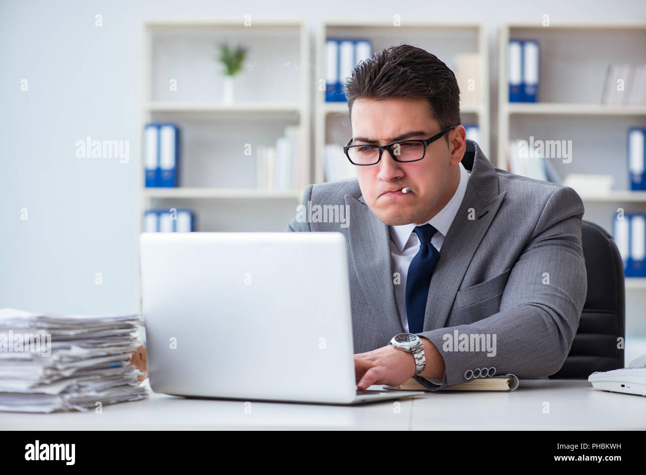 Businessman smoking in office at work Stock Photo - Alamy