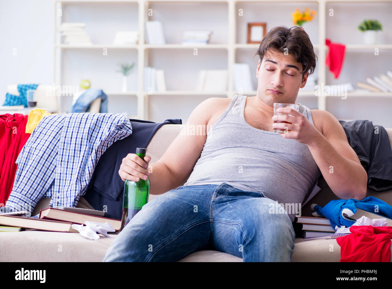 Young man student drunk drinking alcohol in a messy room Stock Photo ...
