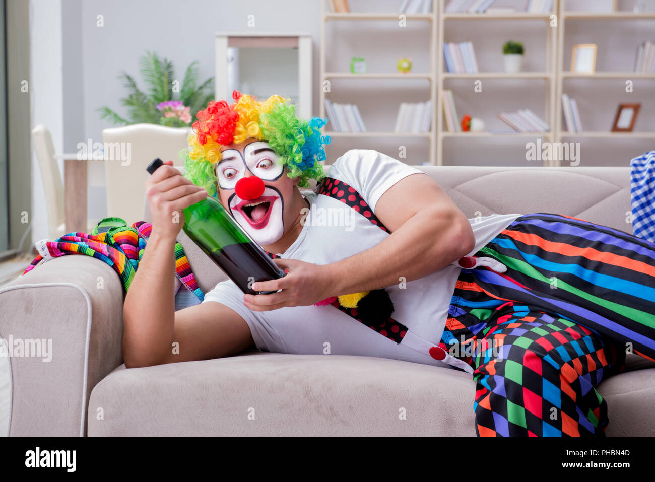 Drunk clown celebrating having a party at home Stock Photo - Alamy