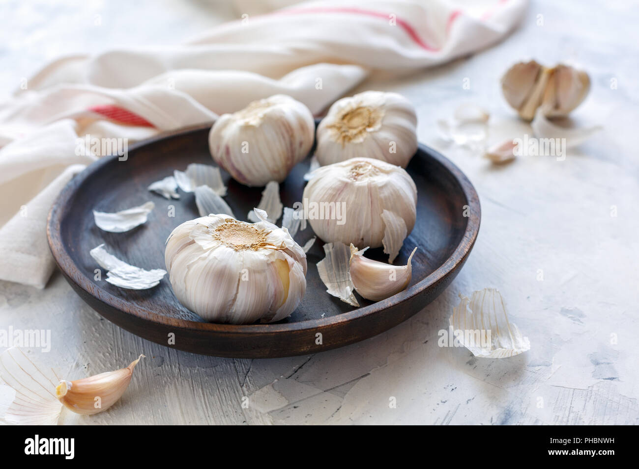 Wooden dish with garlic,cloves and husk Stock Photo - Alamy
