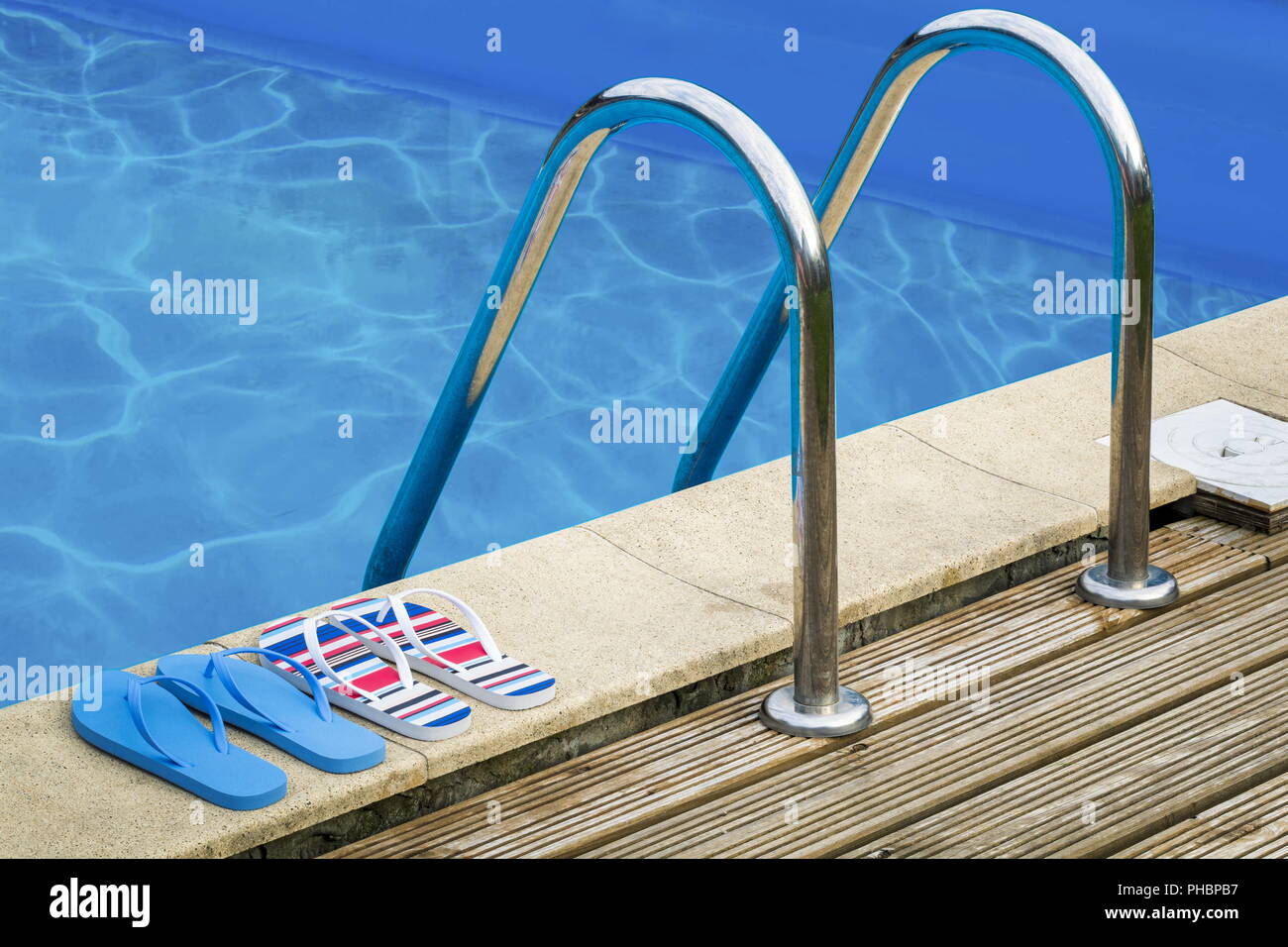 Flip flops and handles at swimming pool Stock Photo - Alamy