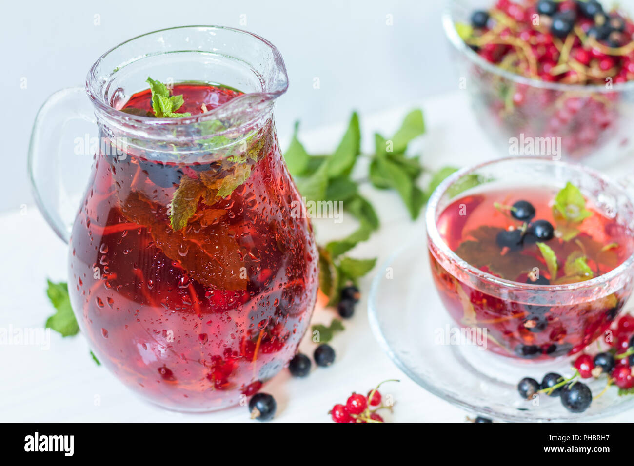 Fruit drink in transparent glass carafe and cup Stock Photo - Alamy