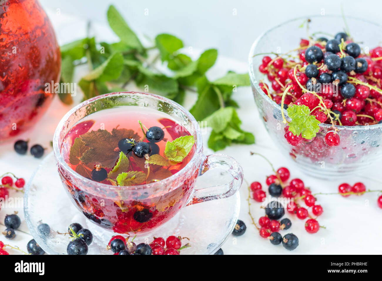 Fruit drink in transparent glass carafe and cup Stock Photo - Alamy