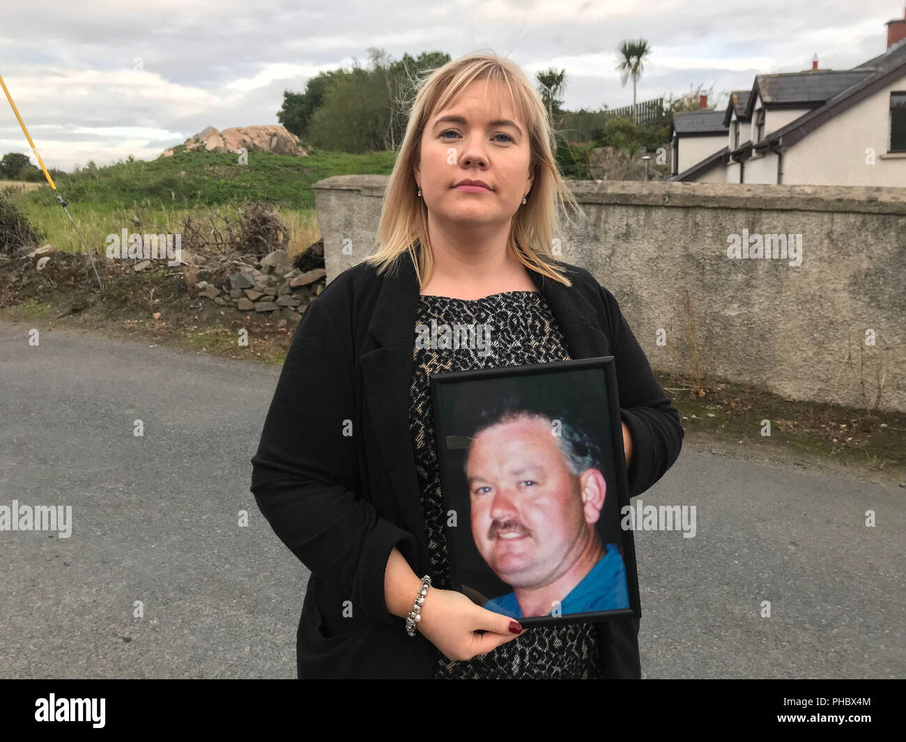 Emma Rogan holding a picture of her father, Adrian, before a vigil held ...