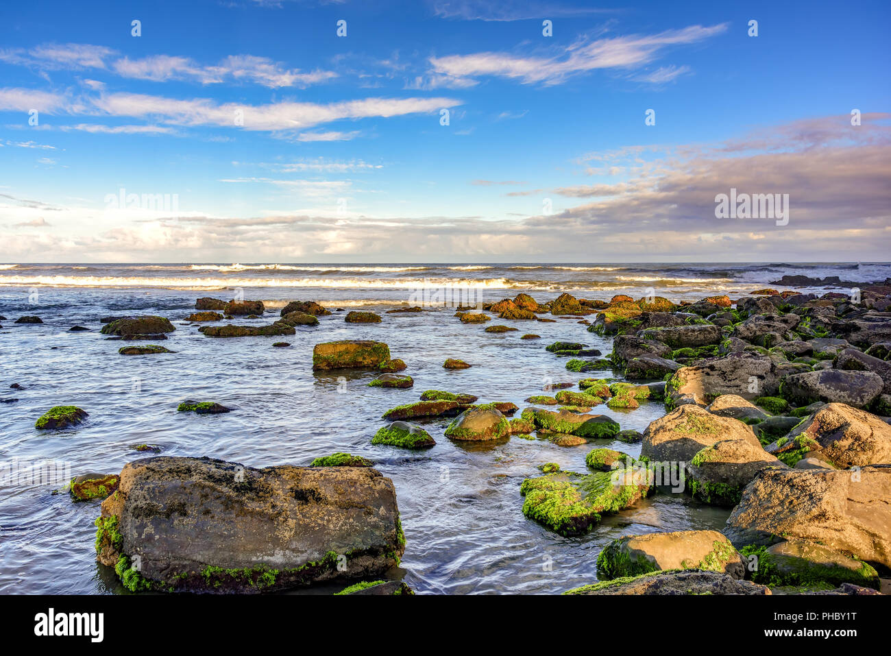 Stones and water with horizon line of Torres city Stock Photo - Alamy