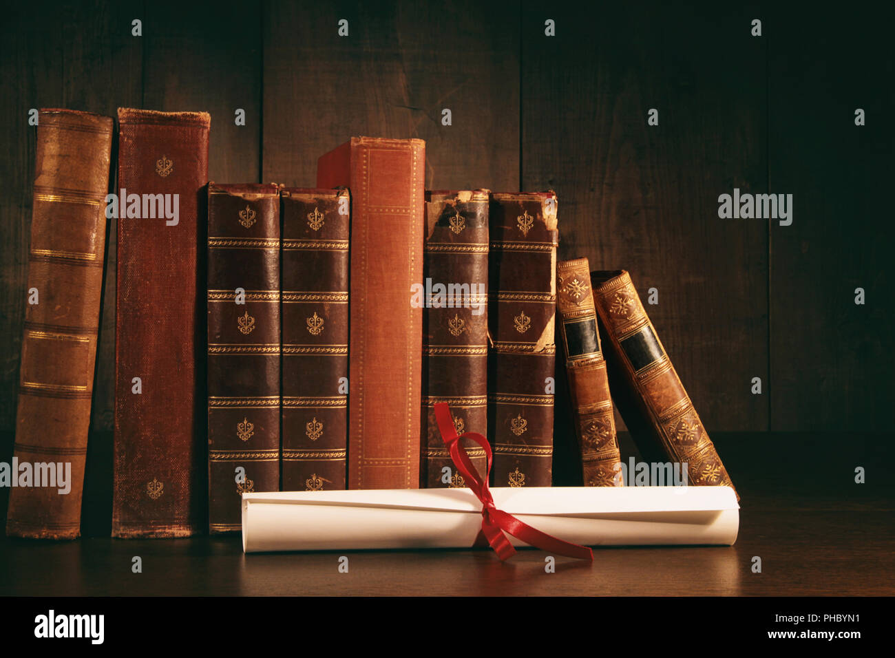 Stack of old books with diploma on desk Stock Photo - Alamy