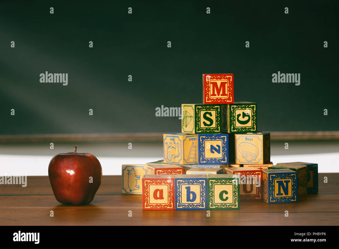 Wooden blocks and apple on desk Stock Photo - Alamy
