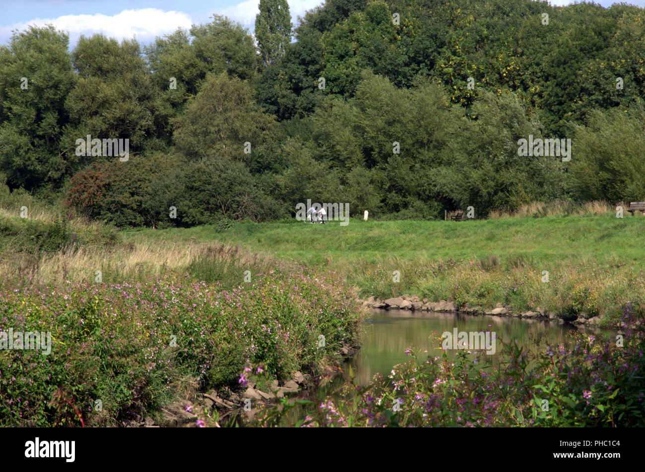 People enjoy the last of the Summer's sunshine beside the river Mersey ...