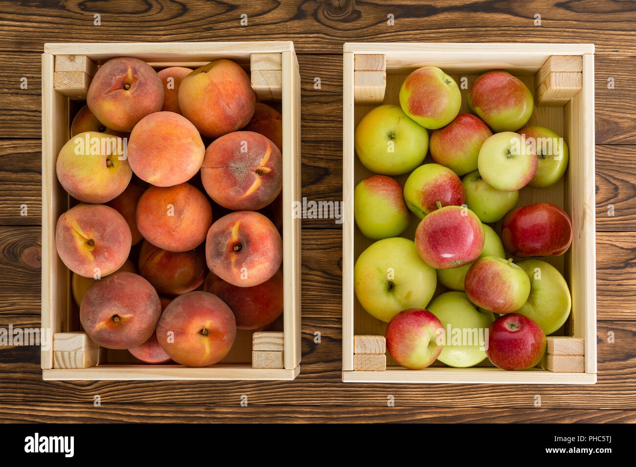 Small wooden crates of healthy fresh fruit filled with ripe peaches and ...
