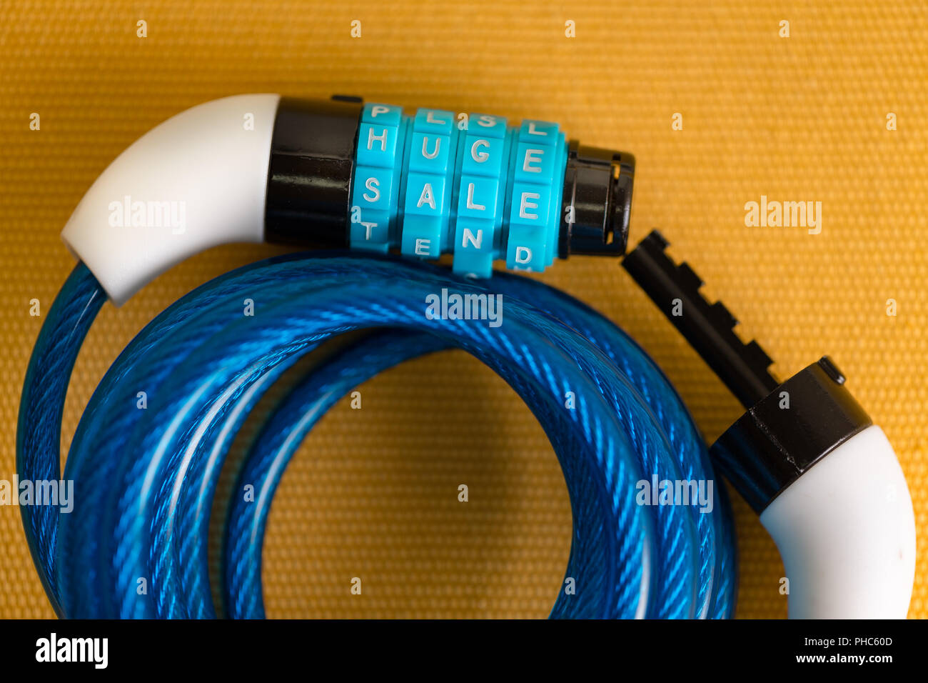 Combination lock on a coiled bike chain covered in blue plastic coating ...