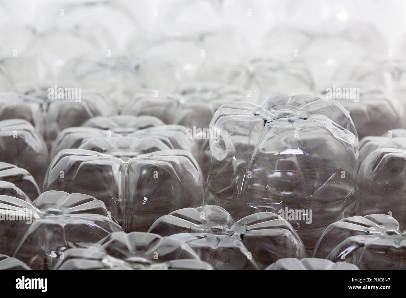 Close up oblique angle of the bottoms of upturned empty plastic bottles ...