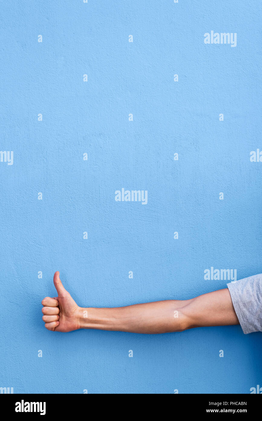 Gesture of approval and praise (Ok!). Thumbs up. Hand on a blue ...