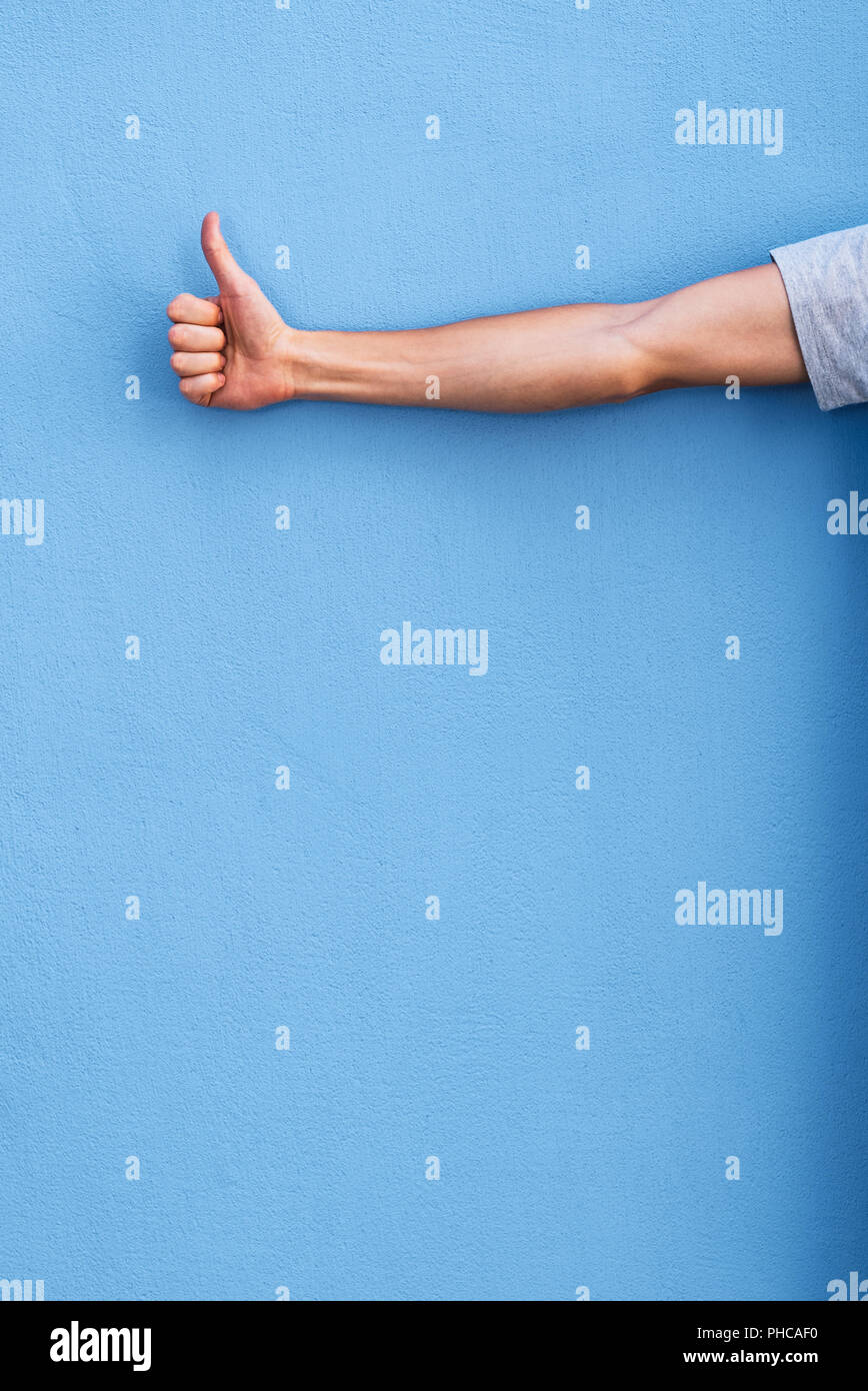Gesture of approval and praise (Ok!). Thumbs up. Hand on a blue ...