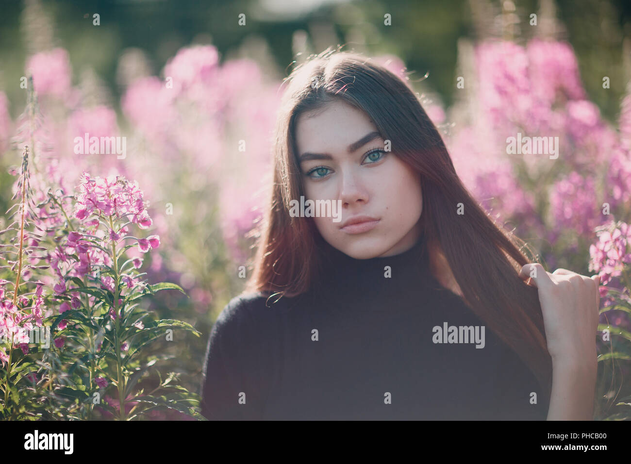 Beautiful young lady in flower field Stock Photo - Alamy