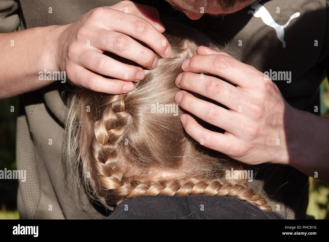 Head lice infection common in young people. Hair being checked using a ...