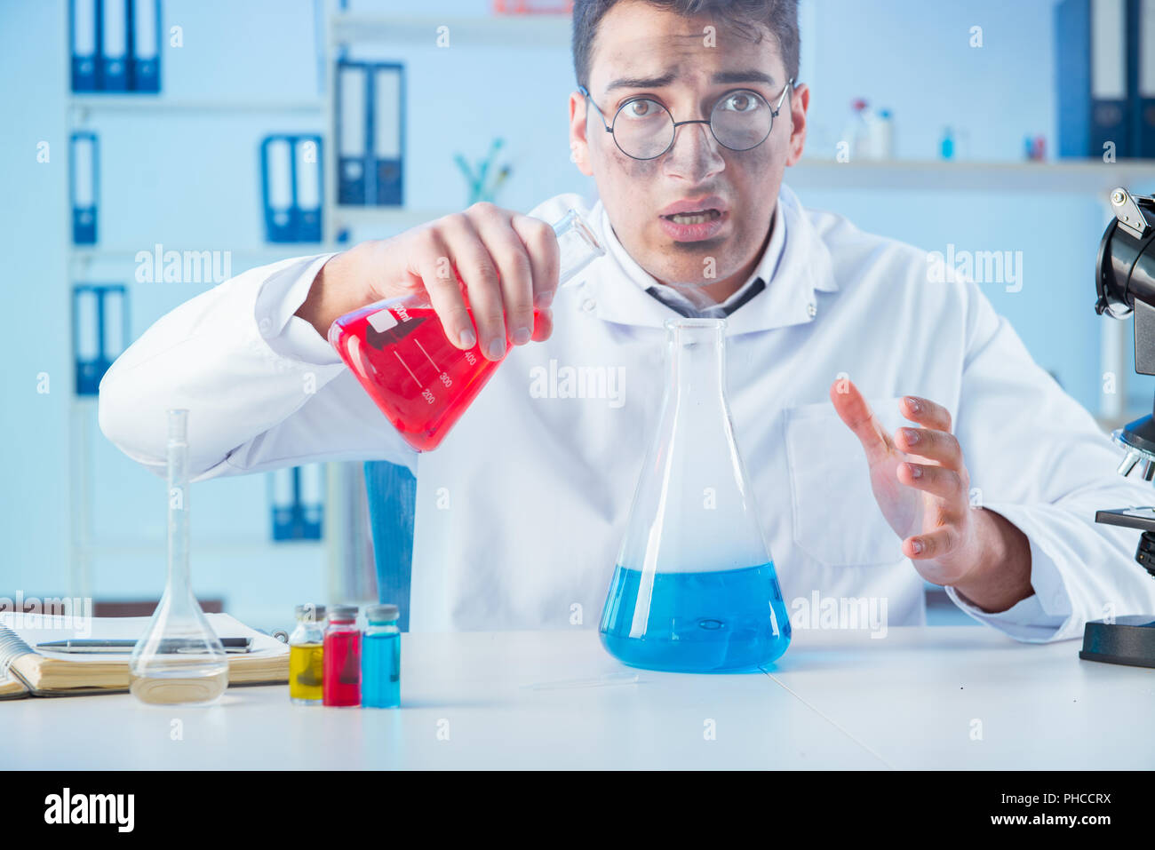 Funny mad chemist working in a laboratory Stock Photo - Alamy
