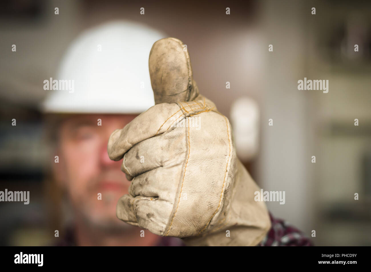 Construction worker showing hand with thumb up Stock Photo - Alamy
