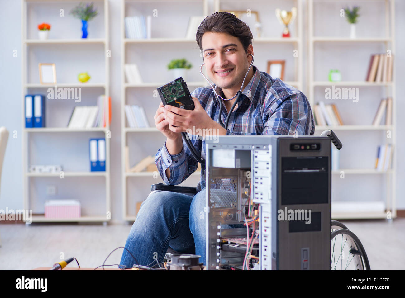 Computer repairman on wheelchair working Stock Photo - Alamy