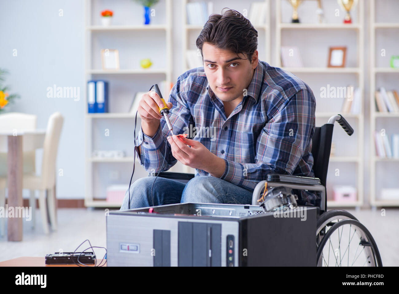 Computer repairman on wheelchair working Stock Photo - Alamy