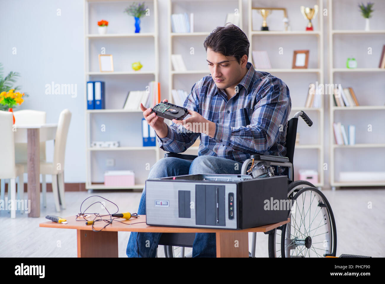 Computer repairman on wheelchair working Stock Photo - Alamy
