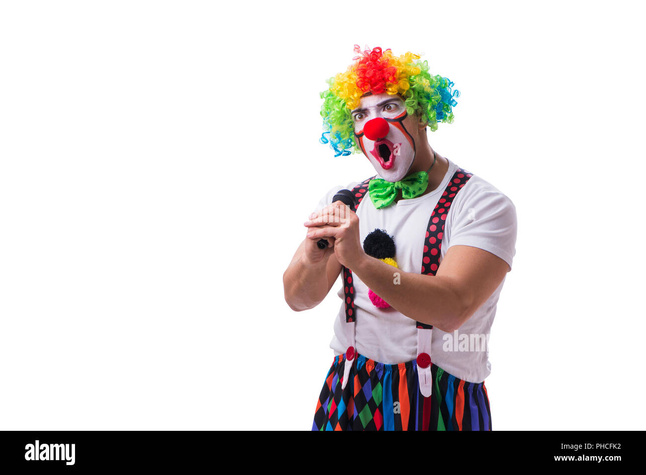 Funny clown with a microphone singing karaoke isolated on white Stock ...