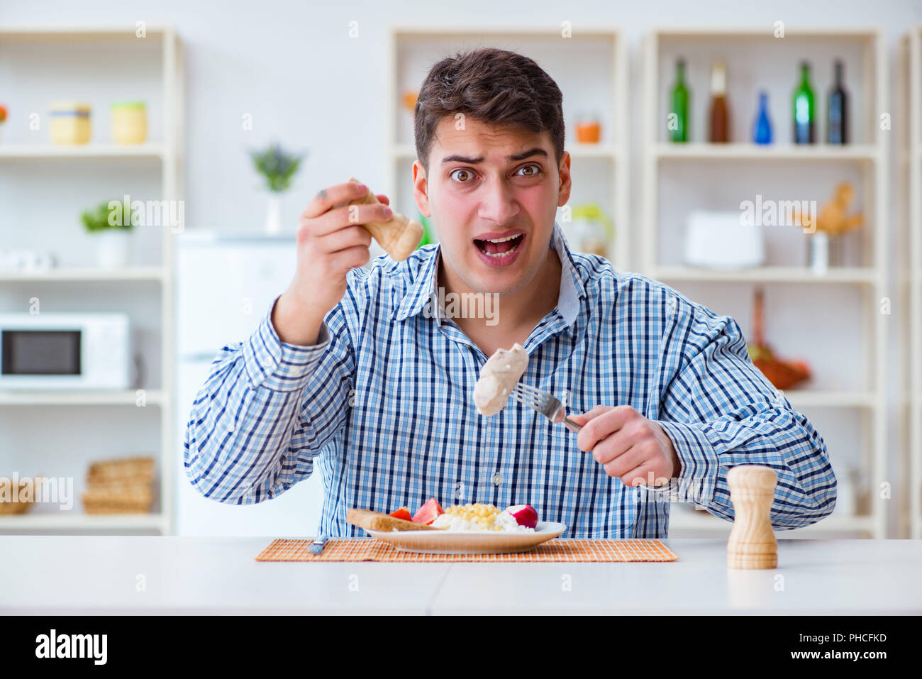 Man eating tasteless food at home for lunch Stock Photo - Alamy