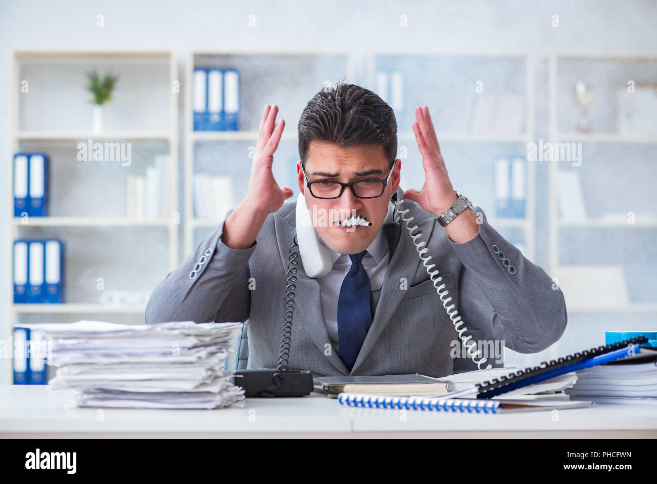 Businessman smoking in office at work Stock Photo - Alamy