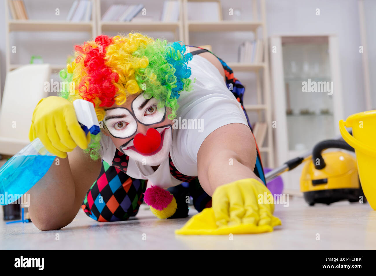 The funny clown doing cleaning at home Stock Photo - Alamy