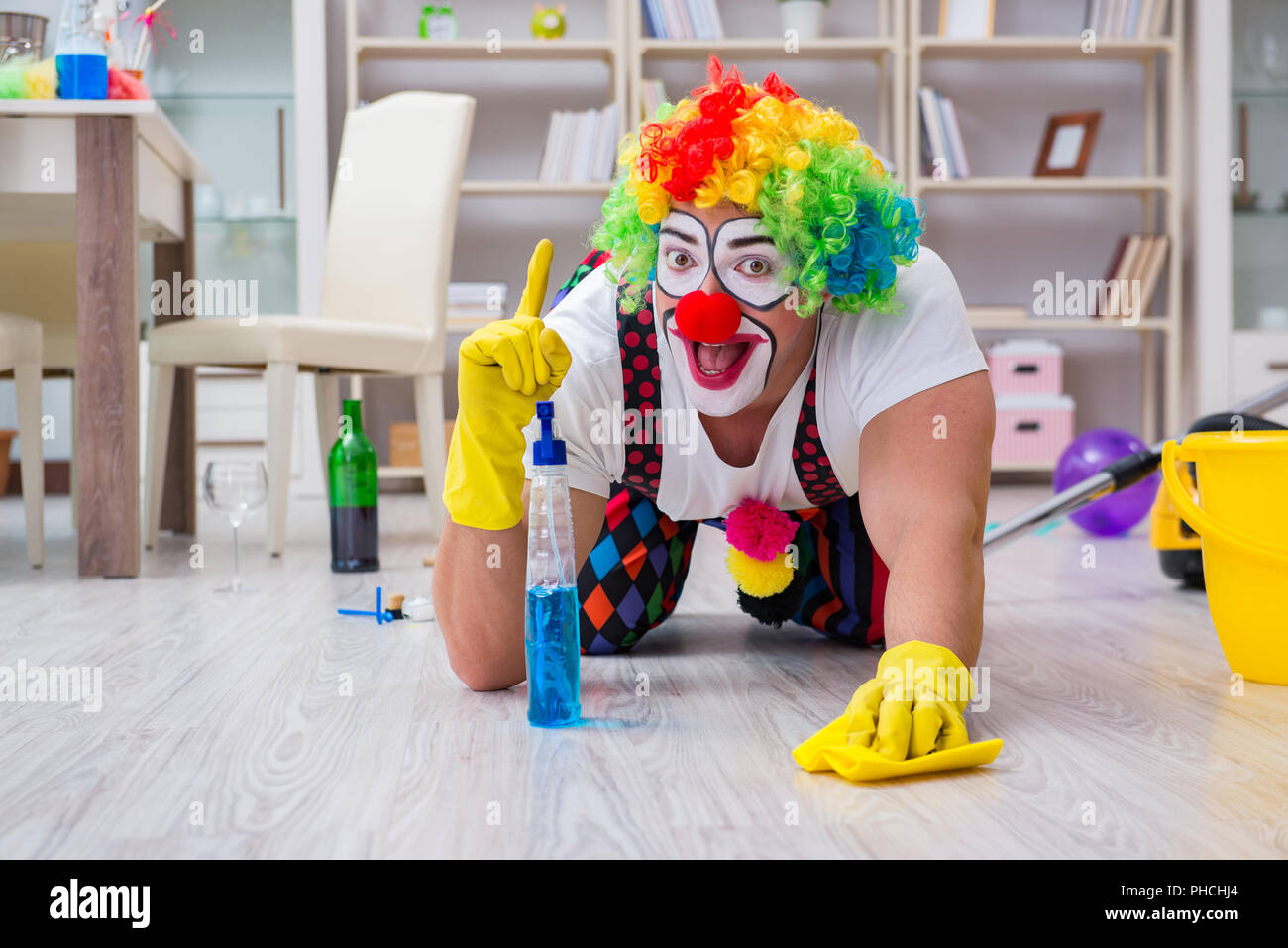 The funny clown doing cleaning at home Stock Photo - Alamy
