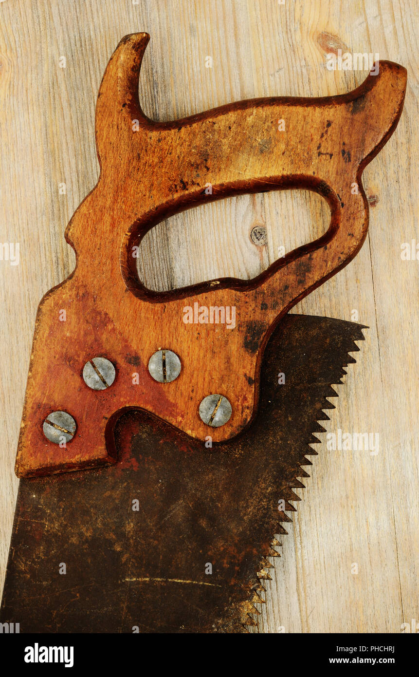 old rusty saw on wooden background with Grunge Filter Stock Photo - Alamy