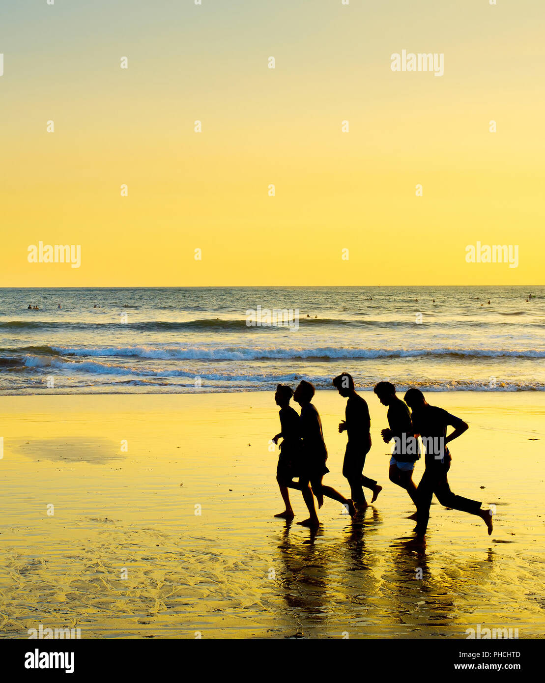 People running ocean beach, Bali Stock Photo - Alamy