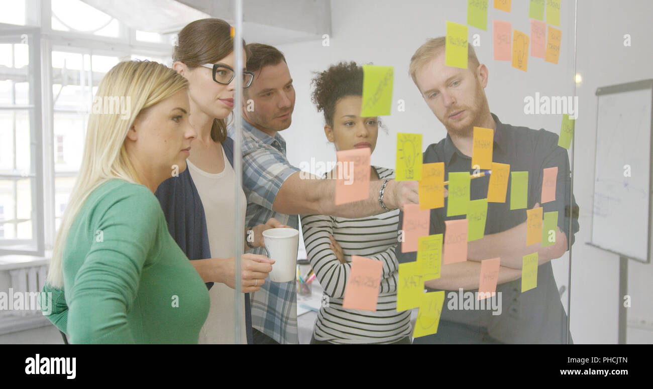 Coworkers brainstorming on new scheme Stock Photo - Alamy