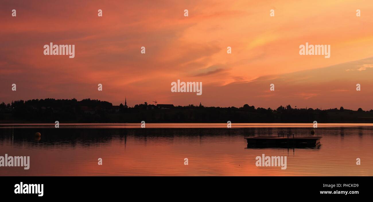 Bright orange sky over lake Pfaeffikon. Summer sunset in Switzerland ...