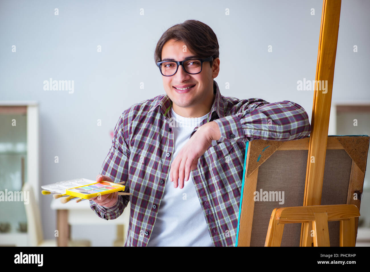 Young male artist drawing pictures in bright studio Stock Photo - Alamy