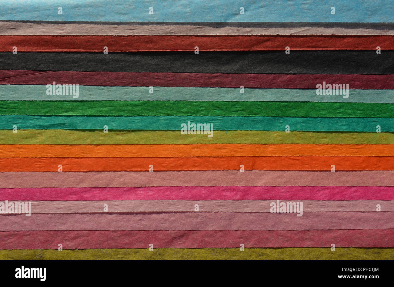 A brightly coloured, striped, tissue paper background with copy space ...