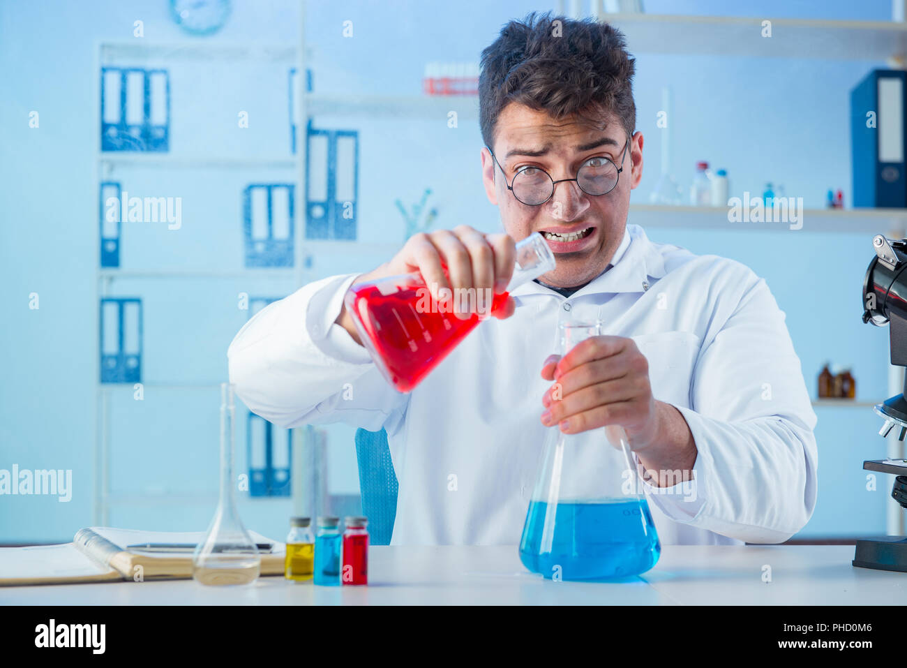 Funny mad chemist working in a laboratory Stock Photo - Alamy