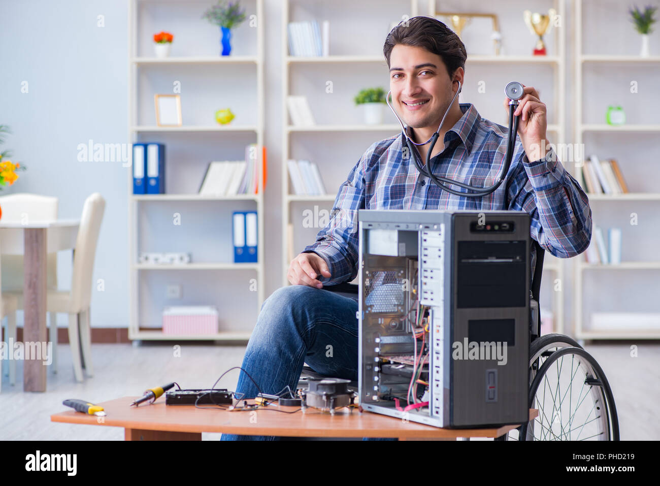 Computer repairman on wheelchair working Stock Photo - Alamy