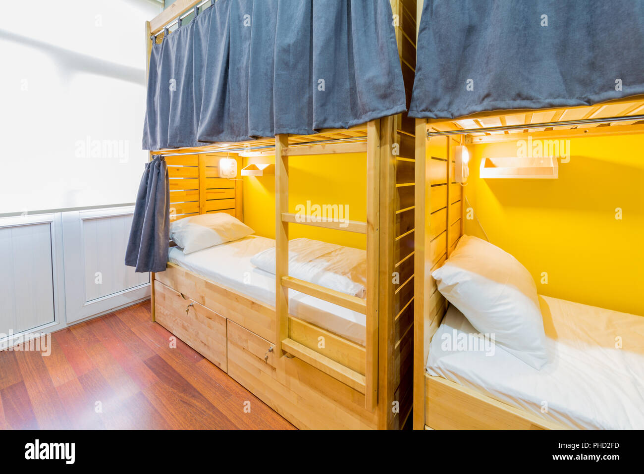 Hostel dormitory beds arranged in room Stock Photo - Alamy