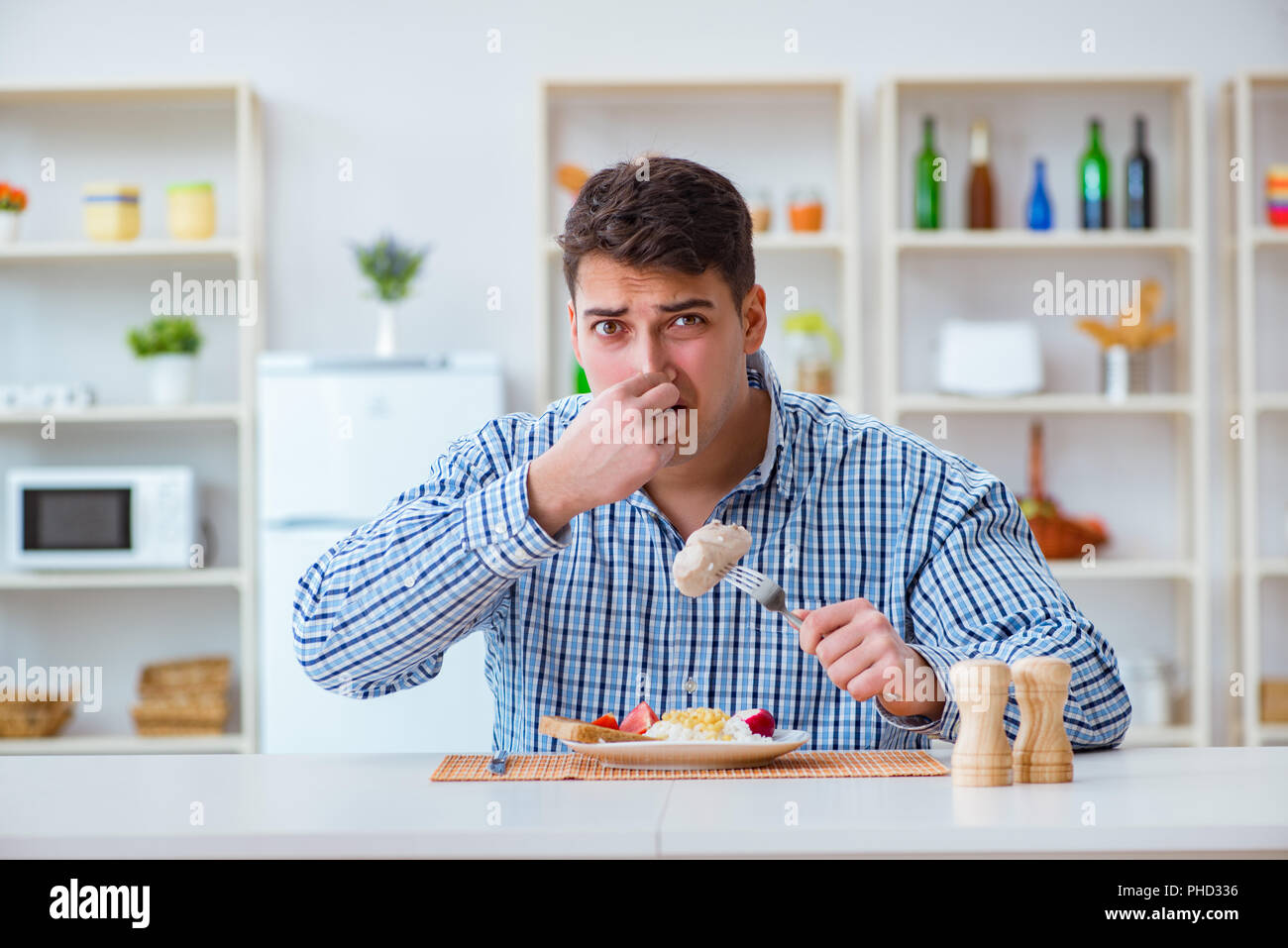 Man eating tasteless food at home for lunch Stock Photo - Alamy