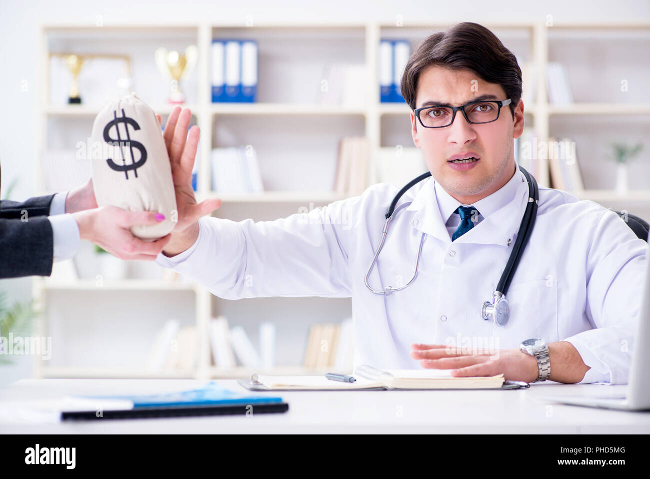 Young doctor in medical insurance fraud concept Stock Photo - Alamy