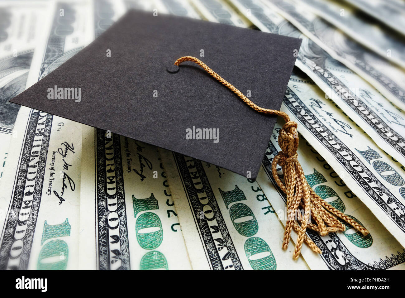 Graduation cap on money Stock Photo - Alamy