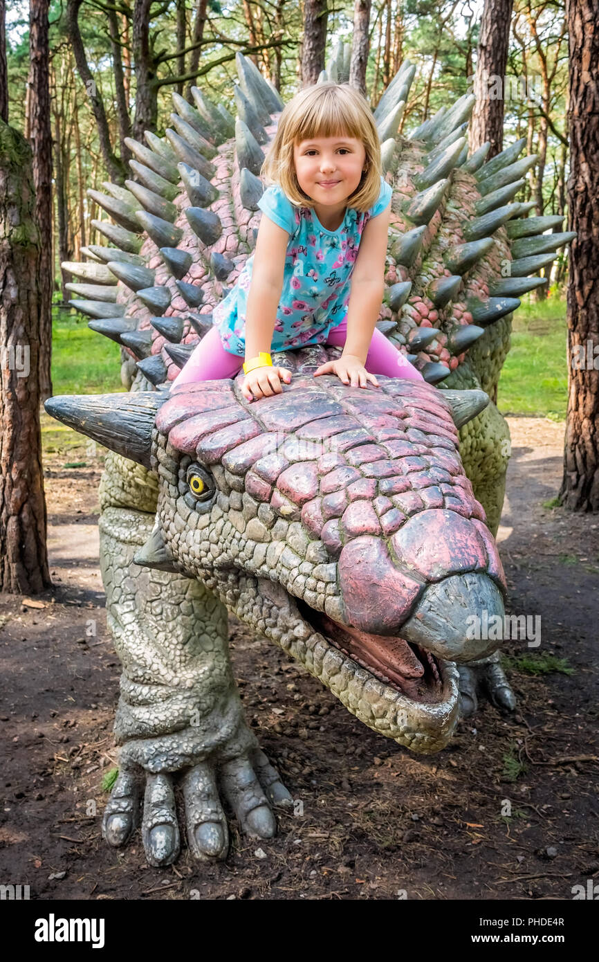 Cute little caucasian girl riding on Ankylosaurus dinosaur Stock Photo ...