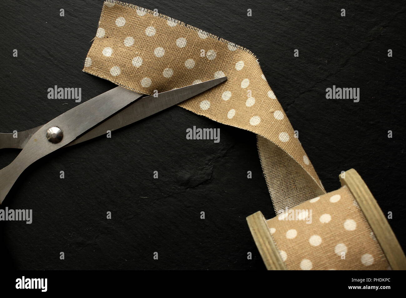 Cotton tape with wooden roll and scissors on black background Stock ...