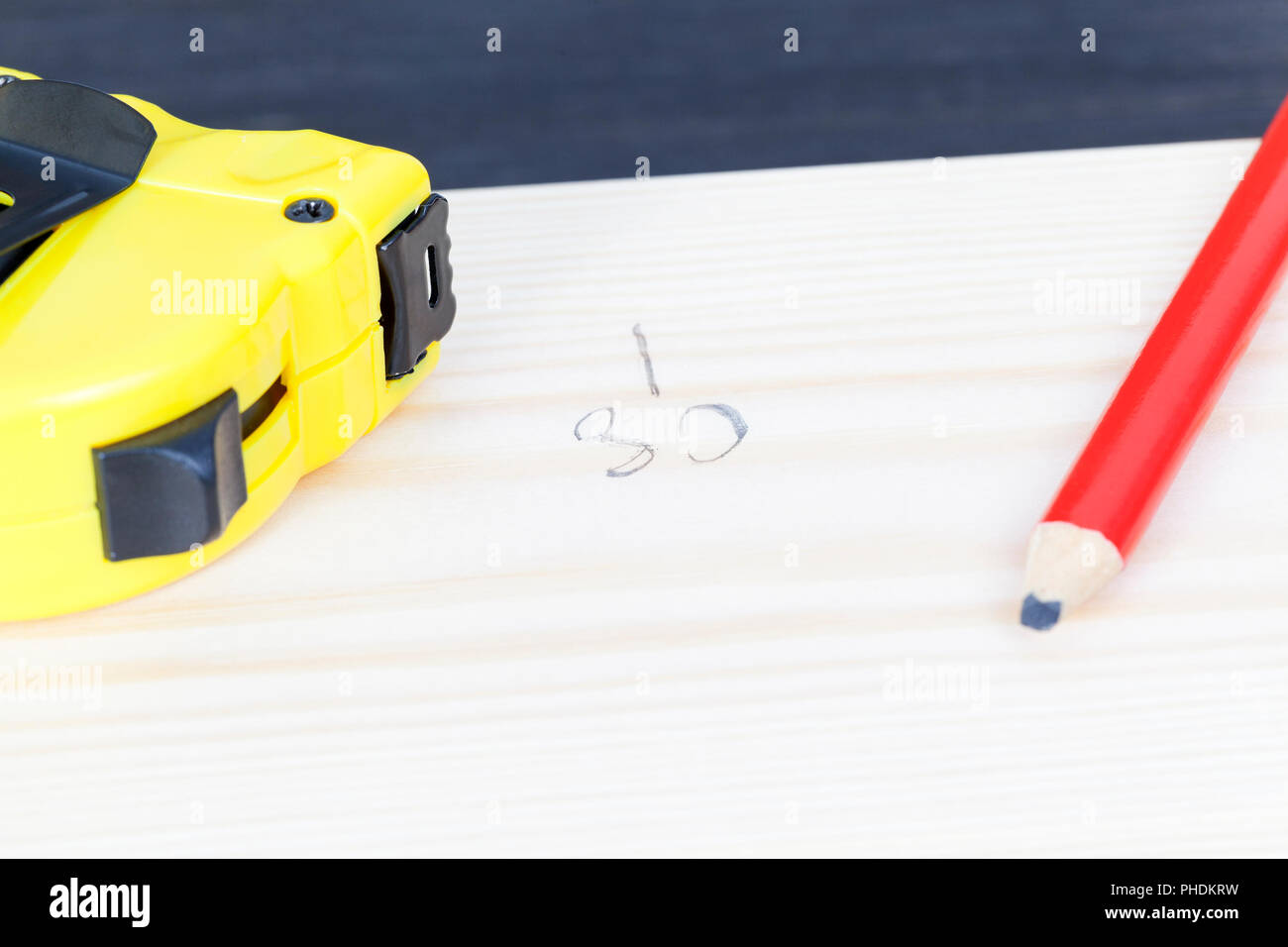 a construction ruler, a red pencil and a board on which the dimensions ...