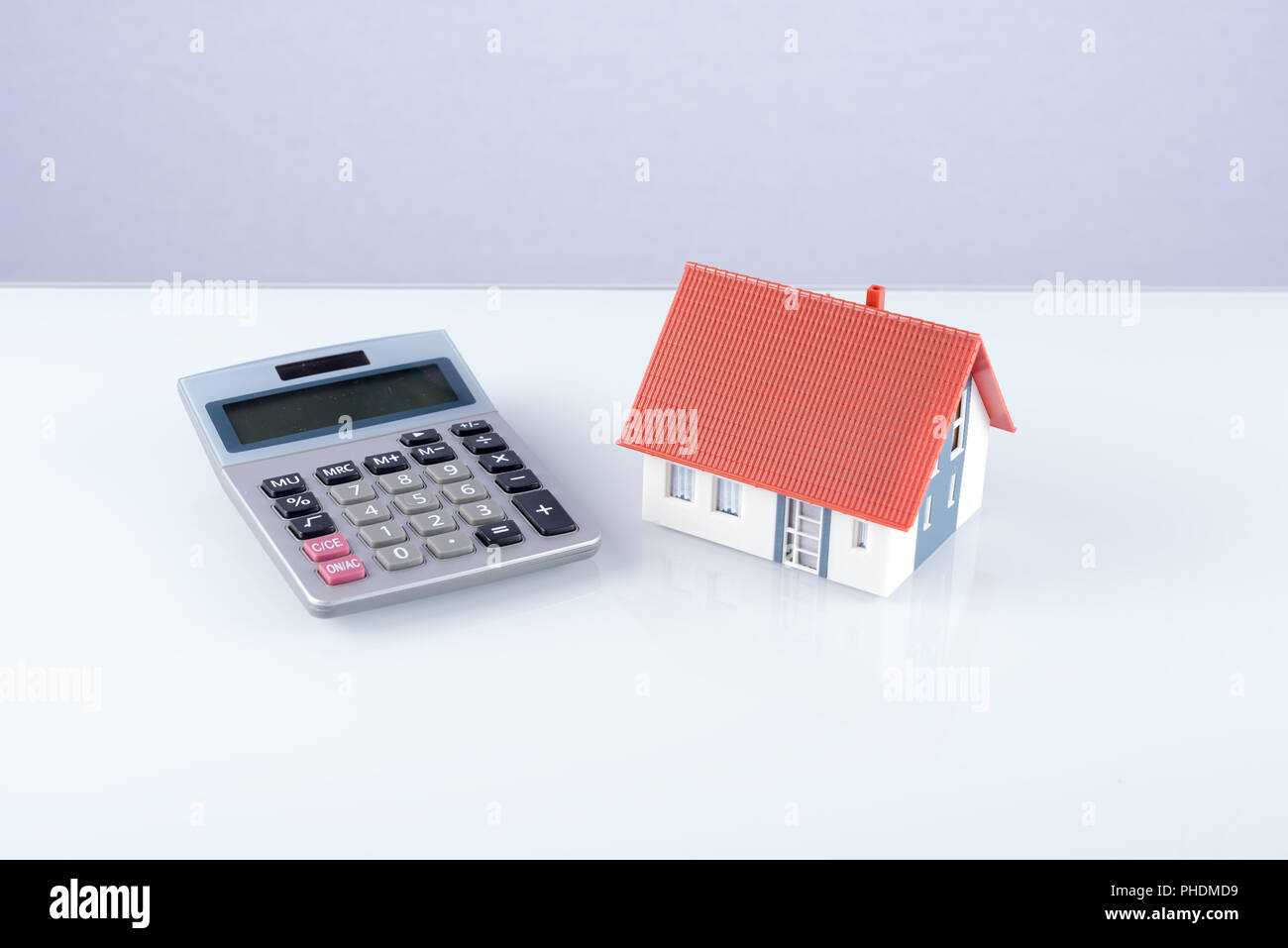 Calculator and model of a house Stock Photo - Alamy
