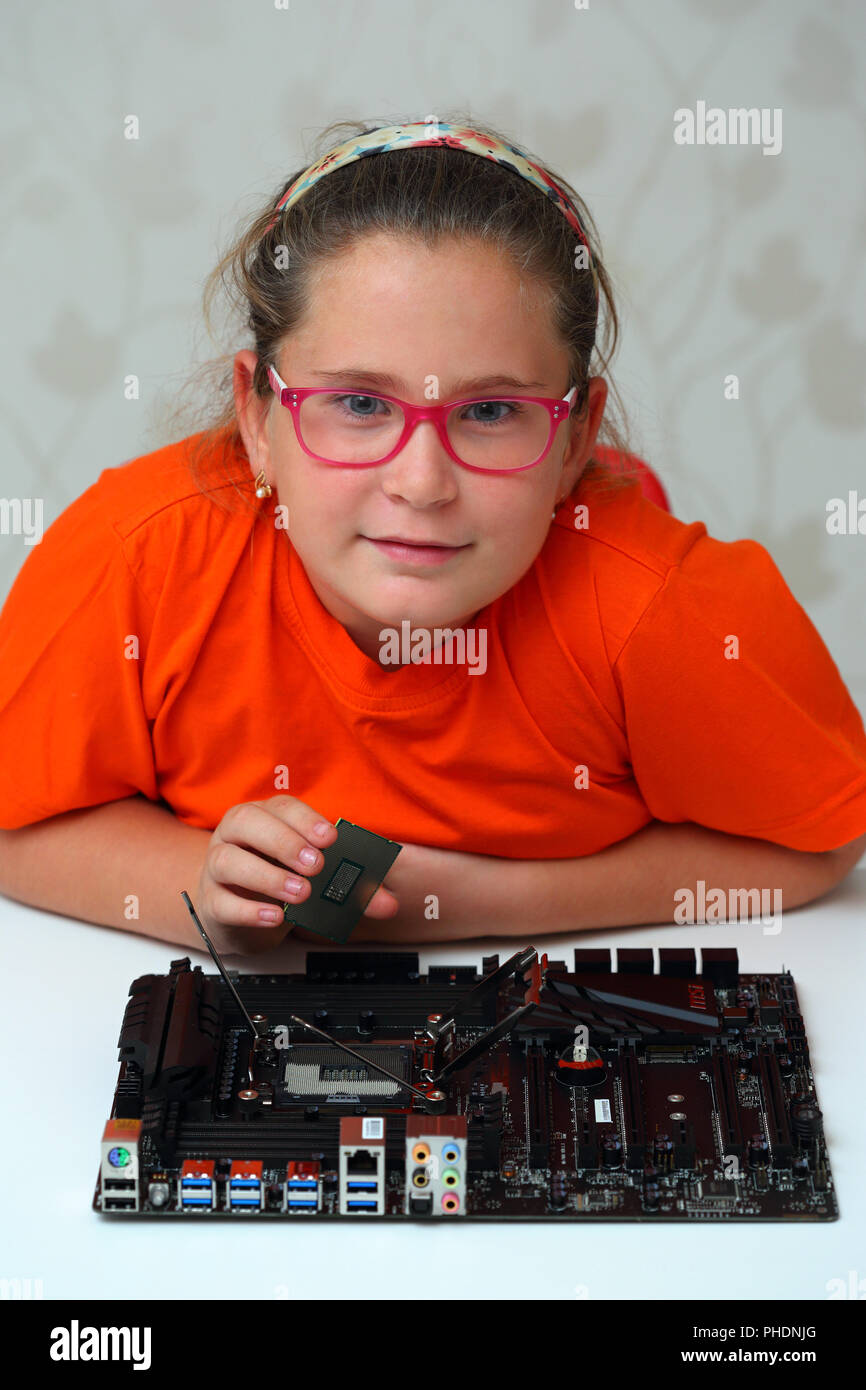 Little girl installs CPU to motherboard Stock Photo - Alamy