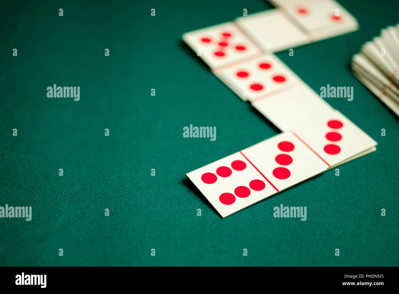 Dominoes playing card on green color table Stock Photo - Alamy