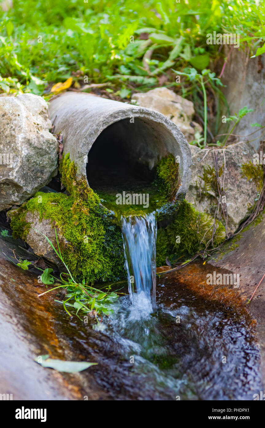 pipe from the ground flowing ecological clean water Stock Photo - Alamy