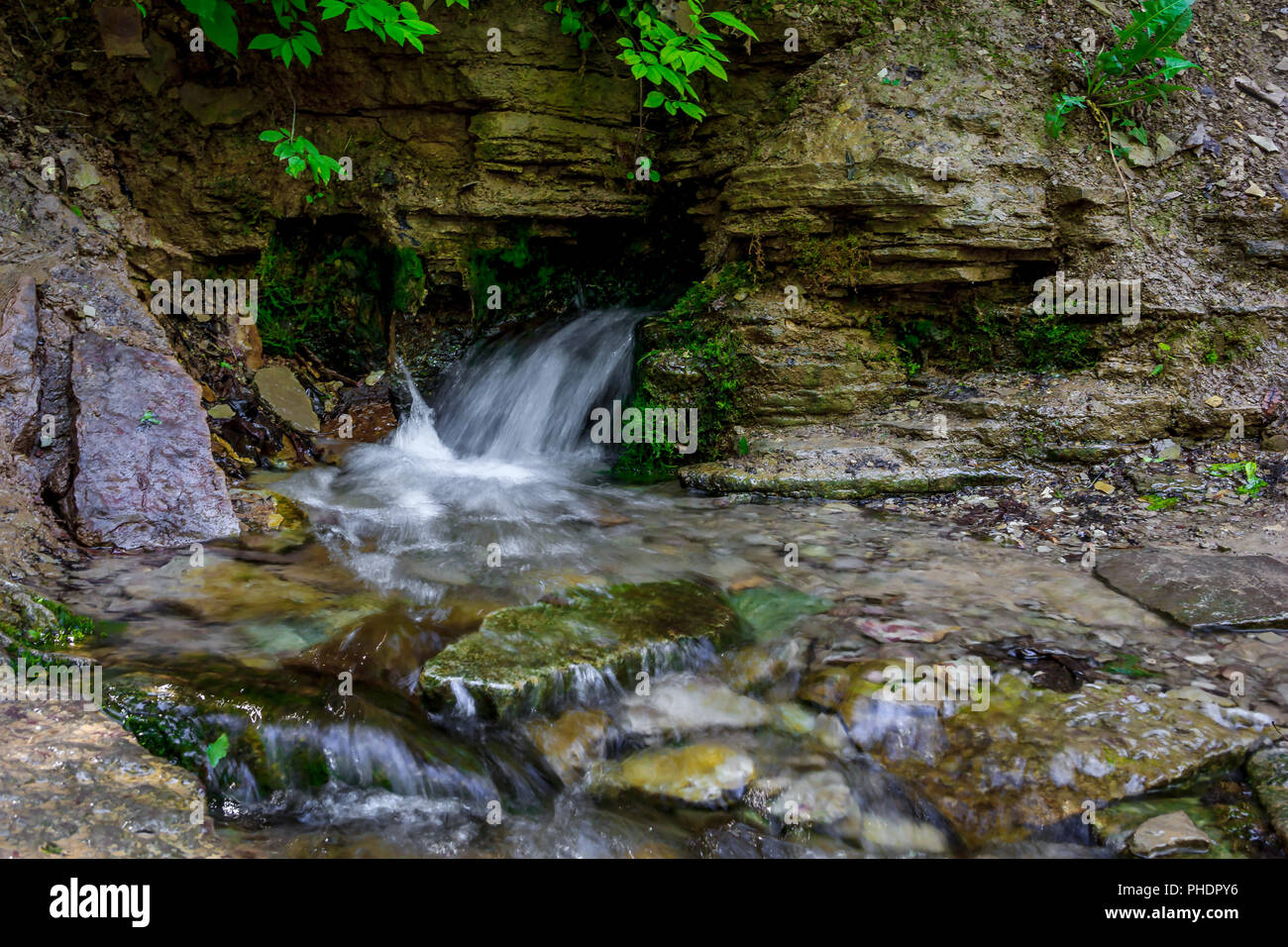 Holy springs in Izborsk. A small waterfall in Russia. Descent of water ...