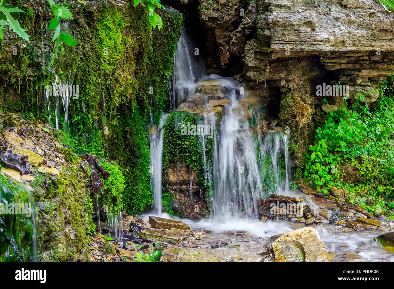 Holy springs in Izborsk. A small waterfall in Russia. Descent of water ...